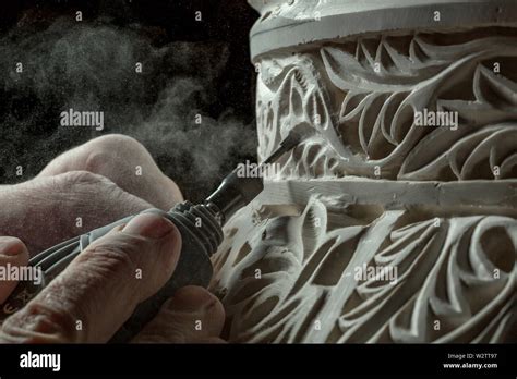 Closeup Dusty Hands Of Unrecognizable Artisan Using Electric Chisel To