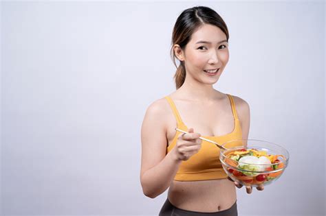 노란색 스포츠웨어를 입은 아시아 여성 흰색 배경에 고립 건강 관리 및 운동의 개념 건강한 생활방식에 대한 스톡 사진 및 기타 이미지 건강한 생활방식 건강한 식생활