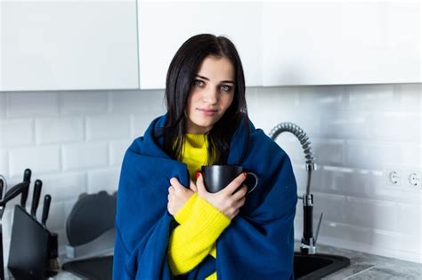 Молодая больная женщина пьет чай на кухне Бесплатно Фото