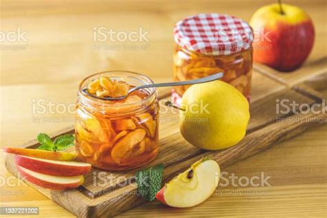 나무 배경에 유리 항아리에 신선한 수제 사과 마멀레이드 잼 몇 가지 신선한 베리와 민트가 근처에 있습니다 가정 생활에 대한 스톡