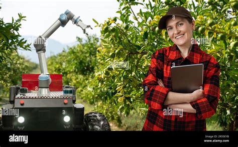 Farmer Controls Autonomous Robot Harvester With Robotic Arm Harvesting Apples On A Smart Farm