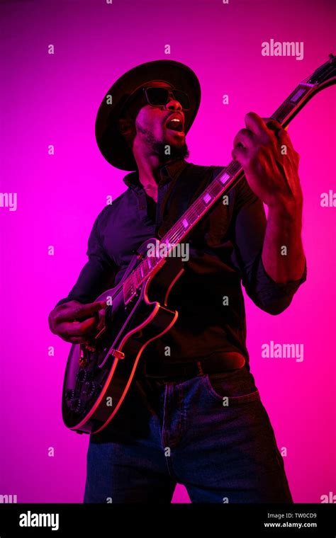 Young African American Musician Playing The Guitar Like A Rockstar On