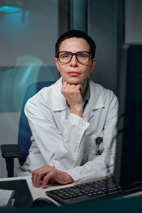 Portrait Of Female Scientist Sitting At Desk Looking Thoughtful Stock