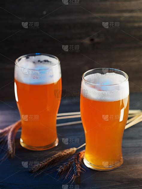 黑色木桌上放着两杯冰镇啤酒