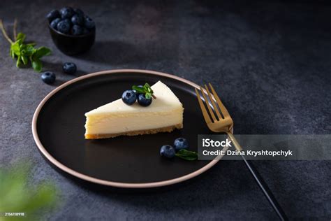어두운 배경에 블루 베리와 민트를 곁들인 맛있는 수제 바닐라 치즈 케이크 조각 클래식 뉴욕 치즈 케이크 건강한 유기농 여름 디저트 측면도 복사 공간 과자 메뉴 레시피 그릇에