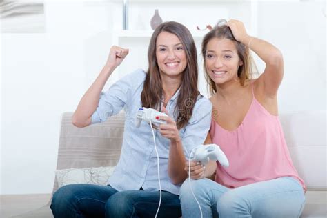 Beautiful Female Friends Having Fun While Playing Video Games Stock