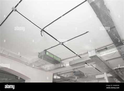 Conduits With Cables And Ventilation System On White Ceiling Low Angle