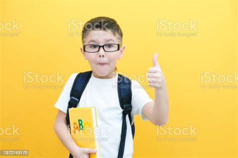 노란 종이 벽에 고립 된 안경을 쓴 어린 소년 좋은 생각 행복한 웃는 여학생은 학교로 돌아갑니다 성공 동기 부여 승자 천재