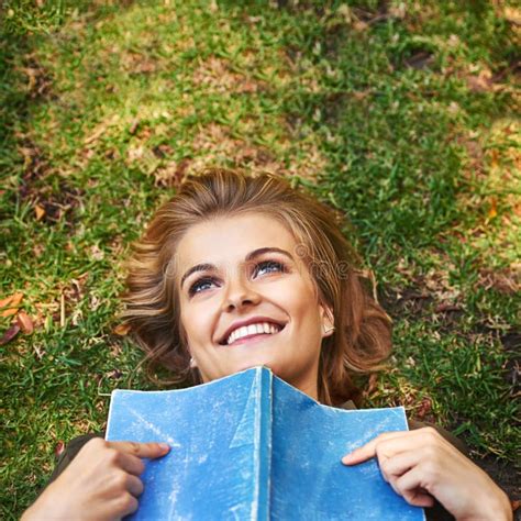 This Book Is Amazingan Young Woman Reading A Book While Lying
