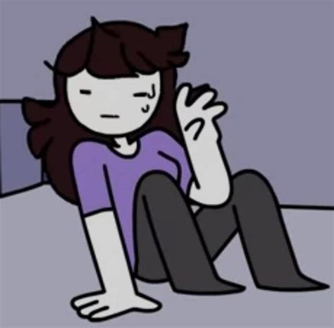 A Woman Sitting On The Floor With Her Hand Up To Her Face And Looking At Something