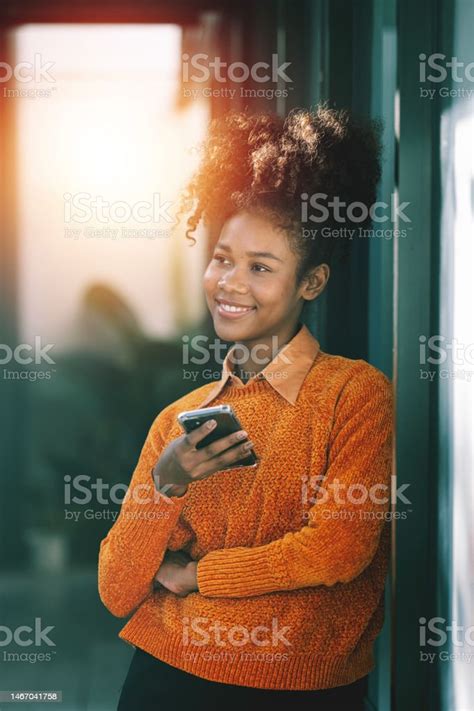 아름다운 젊은 아프리카 여성의 초상화는 일몰 아래 밖에 서서 웃고 있다 휴대 전화를 들고 긍정적인 감정 표현에 대한 스톡 사진 및 기타 이미지 긍정적인 감정 표현 만족