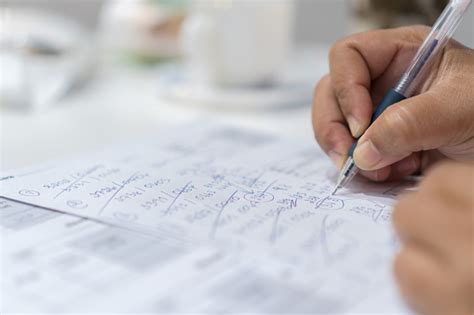 사업가는 서류 대출 서류 및 송장의 보고서를 관리하는 비즈니스 데스크 사무실의 저축 계좌 명세서에서 회사 재정 수입 또는 예산을