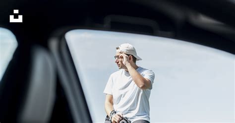 흰색 티셔츠와 검은색 반바지를 입은 남자가 낮에 차창에 앉아 있다 사진 Unsplash의 무료 사람의 이미지