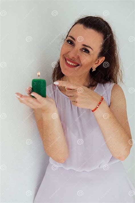 Beautiful Brunette Woman Holding A Green Candle In Her Hands Stock