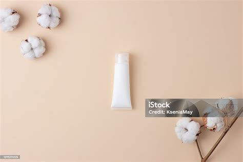 파스텔 베이지 색 배경에 꽃이 있는 화장품 크림의 화이트 튜브 플랫 레이 복사 공간 0명에 대한 스톡 사진 및 기타 이미지