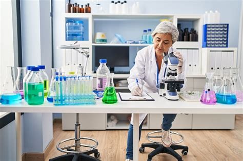 과학자 유니폼을 입은 중년 여성이 실험실에서 문서에 글을 씁니다 55 59세에 대한 스톡 사진 및 기타 이미지 55 59세 Stem 주제 건강 진단 Istock