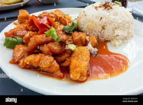 A Plate Of Sweet And Sour Chicken With Boiled Rice A Chinese Inspired