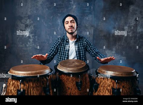 Male Drummer Playing On Wooden Bongo Drums In Factory Shop Musician In Motion Djembe Musical