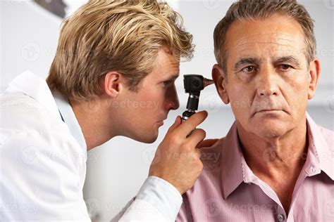 Doctor Examining Male Patient S Ears 962404 Stock Photo At Vecteezy