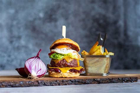 수제 치즈버거는 나무 책상위에 놓았고 양파와 감자 튀김이 있습니다 회색 배경 탁자에 대한 스톡 사진 및 기타 이미지 탁자 프렌치 프라이 감자 요리 Istock