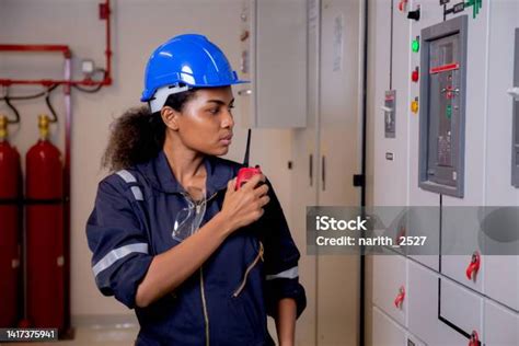 전기 젊은 아시아 여성 엔지니어는 유지 보수 캐비닛 시스템을 전기로 검사하고 산업 공장 기술자 또는 전기 기술자 검사 전력 분배의 제어실에서 라디오를 사용합니다 검사 보기에