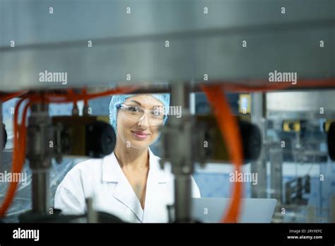 Female Scientist In White Coat And Blue Hat Working In The Control