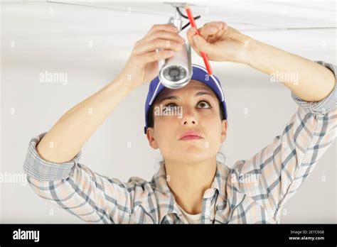 Female Electrician Installing Lights In Ceiling Stock Photo Alamy