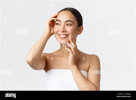Beautiful Tender Asian Girl In Towel Looking Away Pleased Touching Clean Face No Acne