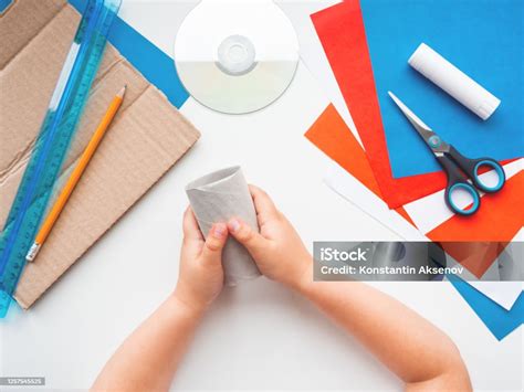 아이는 색종이와 사용 화장지 코어의 환경 친화적 인 장난감을 만든다 또한 그는 판지 가위 접착제 Cd 디스크 연필 및 눈자가 필요합니다 조직 롤을 재사용 즉석 재료에서