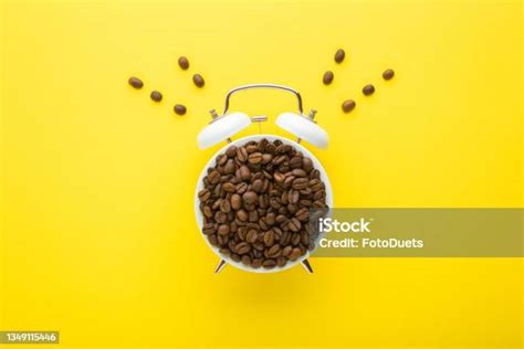 밝은 노란색 테이블 배경에 흰색 알람 시계의 얼굴에 신선한 커피 콩 근접 촬영 아침 시간 개념 하향 보기 갈색에 대한 스톡 사진 및 기타 이미지 Istock