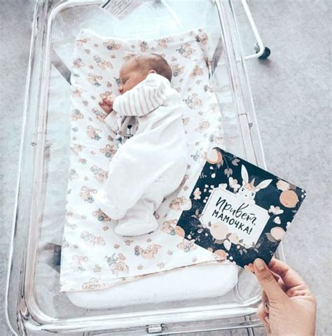 a person holding a book in front of a baby