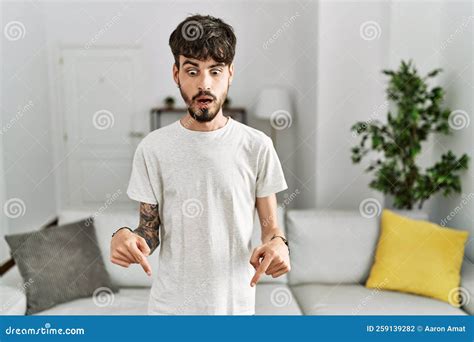 Hispanic Man With Beard At The Living Room At Home Pointing Down With