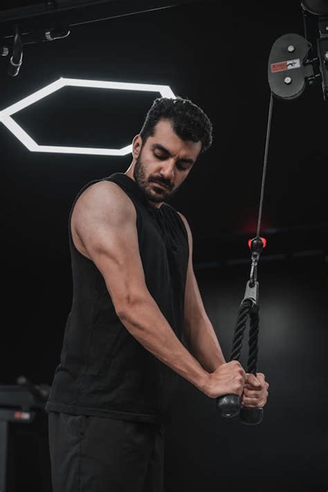 체육관에서 케이블 머신으로 운동하는 청년 · 무료 스톡 사진