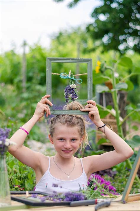 Beautiful Blond Girl In Floral Garden Holding Wooden Frames With Purple