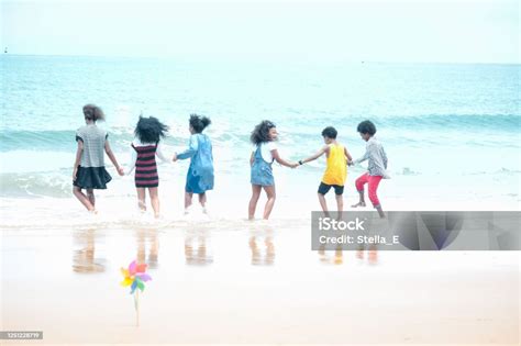 바다 물로 달리는 줄에서 손을 잡고 있는 여섯 명의 소년과 소녀 그룹 모래 여름 해변에서 즐거운 시간을 보내는 귀여운 아이들