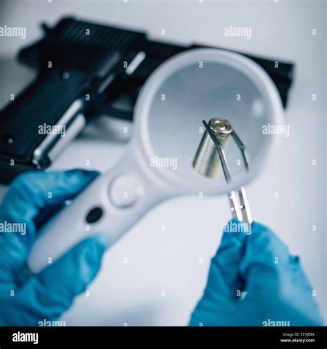 Forensic Science In Lab Forensic Scientist Examining Bullet Shell For