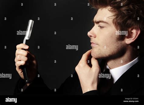 Low Key Image Of A Youn Man Holding A Cut Throat Razor What Could His Intentions Be Stock Photo