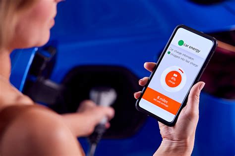 배터리 잔량을 모니터링하기 위해 휴대 전화에서 앱을 사용하여 케이블로 전기 자동차를 충전하는 여성 30 34세에 대한 스톡 사진 및 기타 이미지 Istock