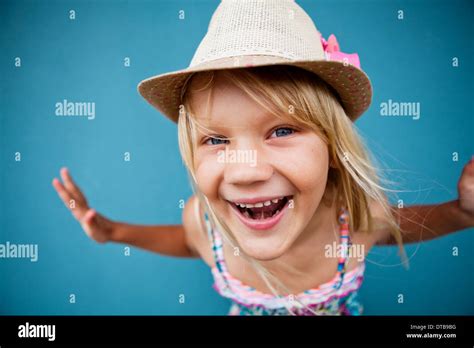 Portrait Of Stylish Cute Young Girl Being Playful Outside Against Blue