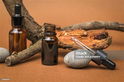 두 개의 유리 드롭퍼 병 오래된 나무와 갈색 배경에 돌 천연 미네랄을 기반으로 한 화장품 및 의약품 마사지에 대한 스톡 사진 및