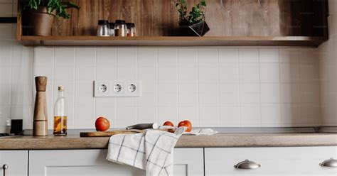 회색 색상의 가구와 나무 테이블 상판으로 현대적인 주방에서 음식을 요리합니다 야채 후추 향신료와 나무 도마에 칼 스칸디나비아 스타일의 세련된 주방 인테리어 사진