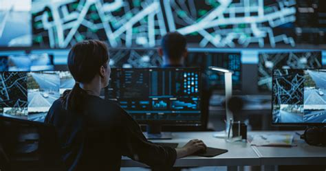 컴퓨터를 사용하여 실시간 Cctv 영상을 모니터링하는 여성 경찰관의 뒷모습 대형 디지털 스크린이 있는 현대적인 모니터링 사무실과