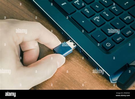 Male Hand Connecting A Black USB Cable To The USB Port Of A Black Notebook Stock Photo Alamy