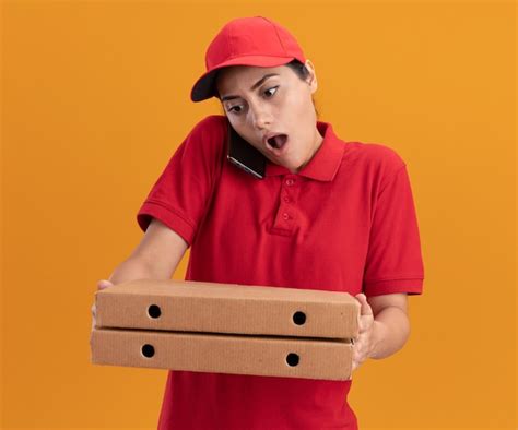 Free Photo Surprised Young Delivery Girl Wearing Uniform And Cap