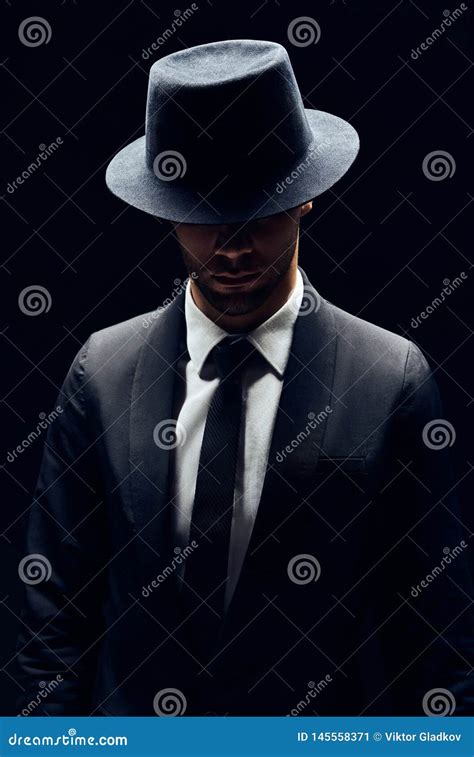 Handsome Confident Man In Black Suit And Hat On Dark Background Stock