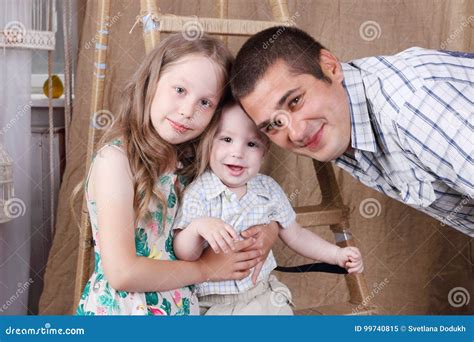 Счастливый отец маленькая дочь и сын усмехаются и представляются Стоковое Изображение