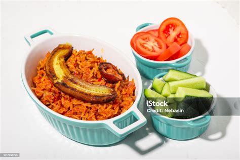 튀긴 바나나와 졸로보 쌀 신선한 야채 토마토와 오이 흰색 배경입니다 토마토 양파 향신료를 곁들인 전통적인 나이지리아 쌀 식품 쌀