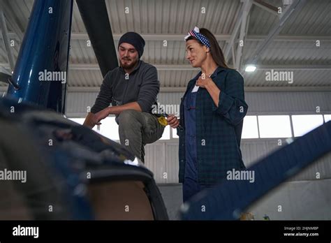 Two Engineers Using Special Tools While Analyzing Details Of Copter In Hangar Stock Photo Alamy