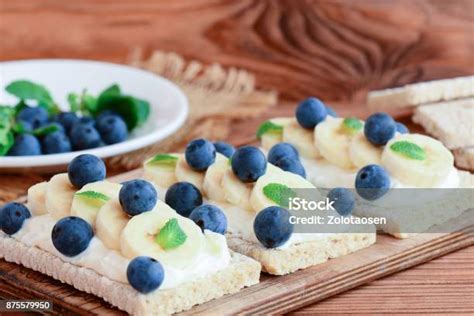 코 티 지 치즈 바나나와 딸기 나무 보드 홈 Crispbread 토스트 코 티 지 치즈 사진 건강 한 샌드위치입니다 근접 촬영