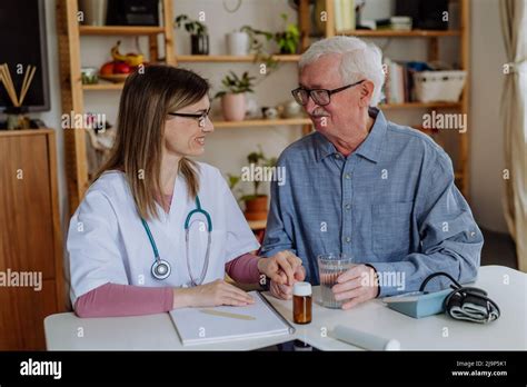 Healthcare Worker Or Caregiver Visiting Senior Man Indoors At Home